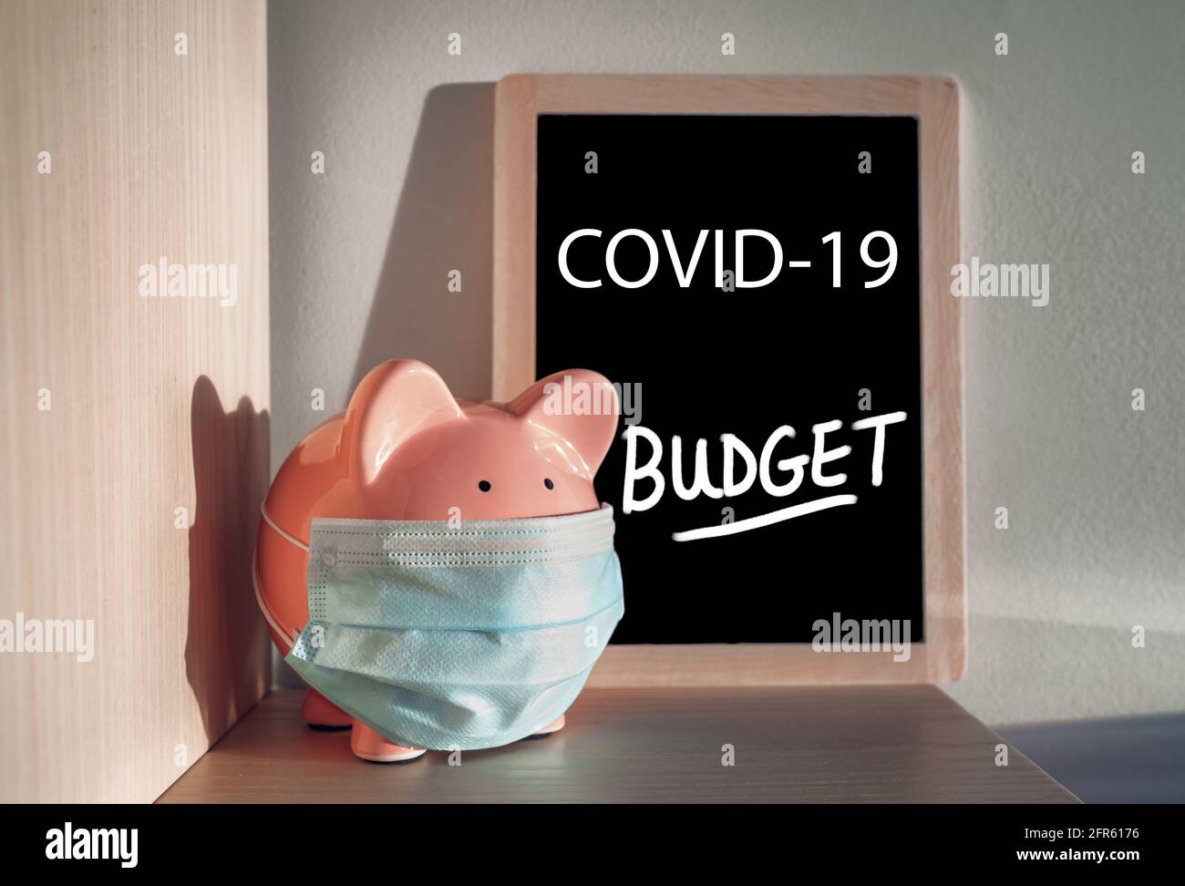 Coronavirus pandemic economic crisis blackboard. Piggy bank wearing ...
