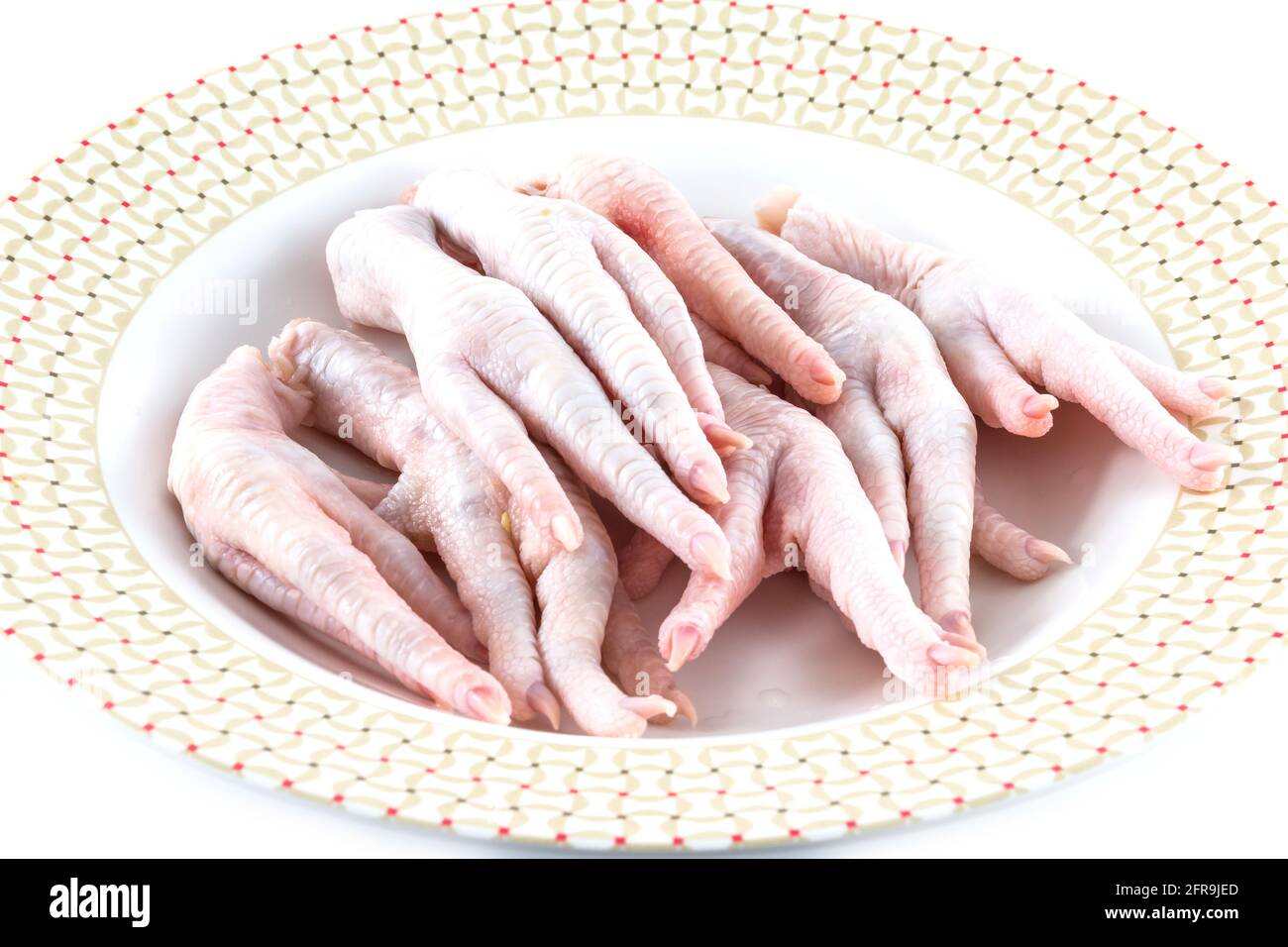 Chicken feet on white disk on white background Stock Photo - Alamy