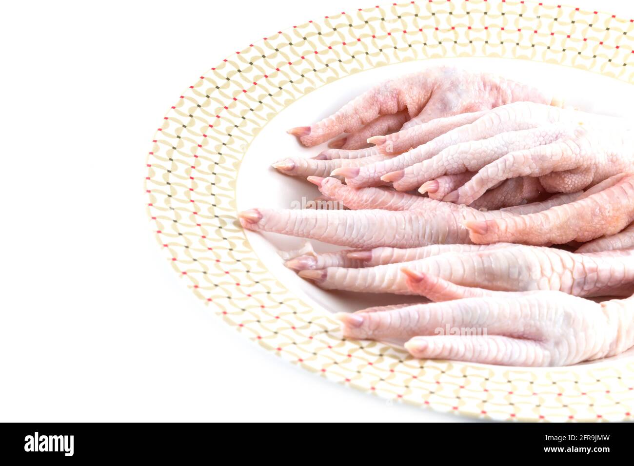 Chicken feet on white disk on white background Stock Photo - Alamy