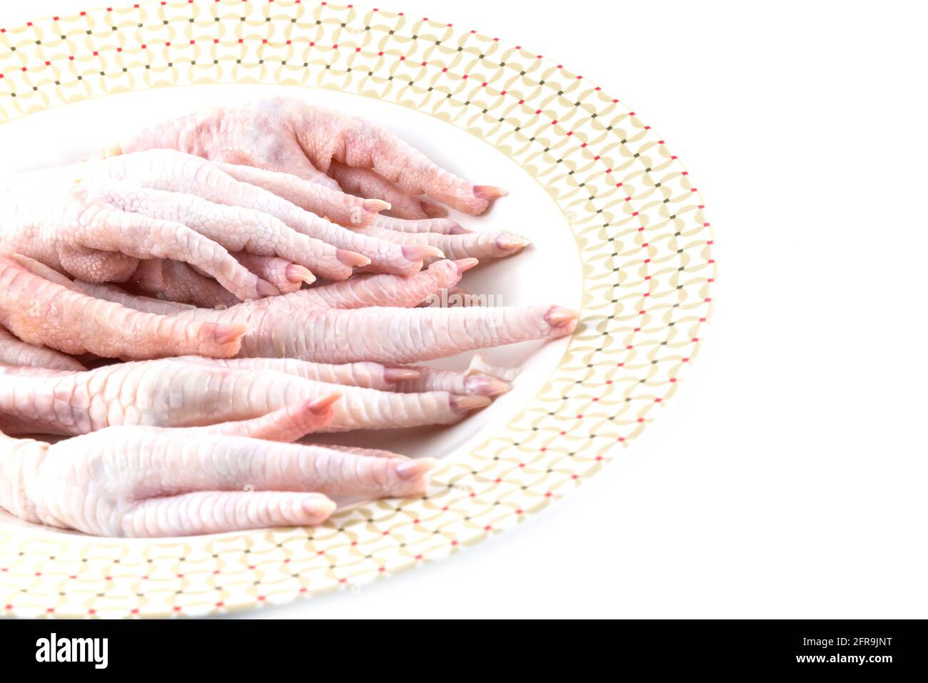 Chicken feet on white disk on white background Stock Photo - Alamy
