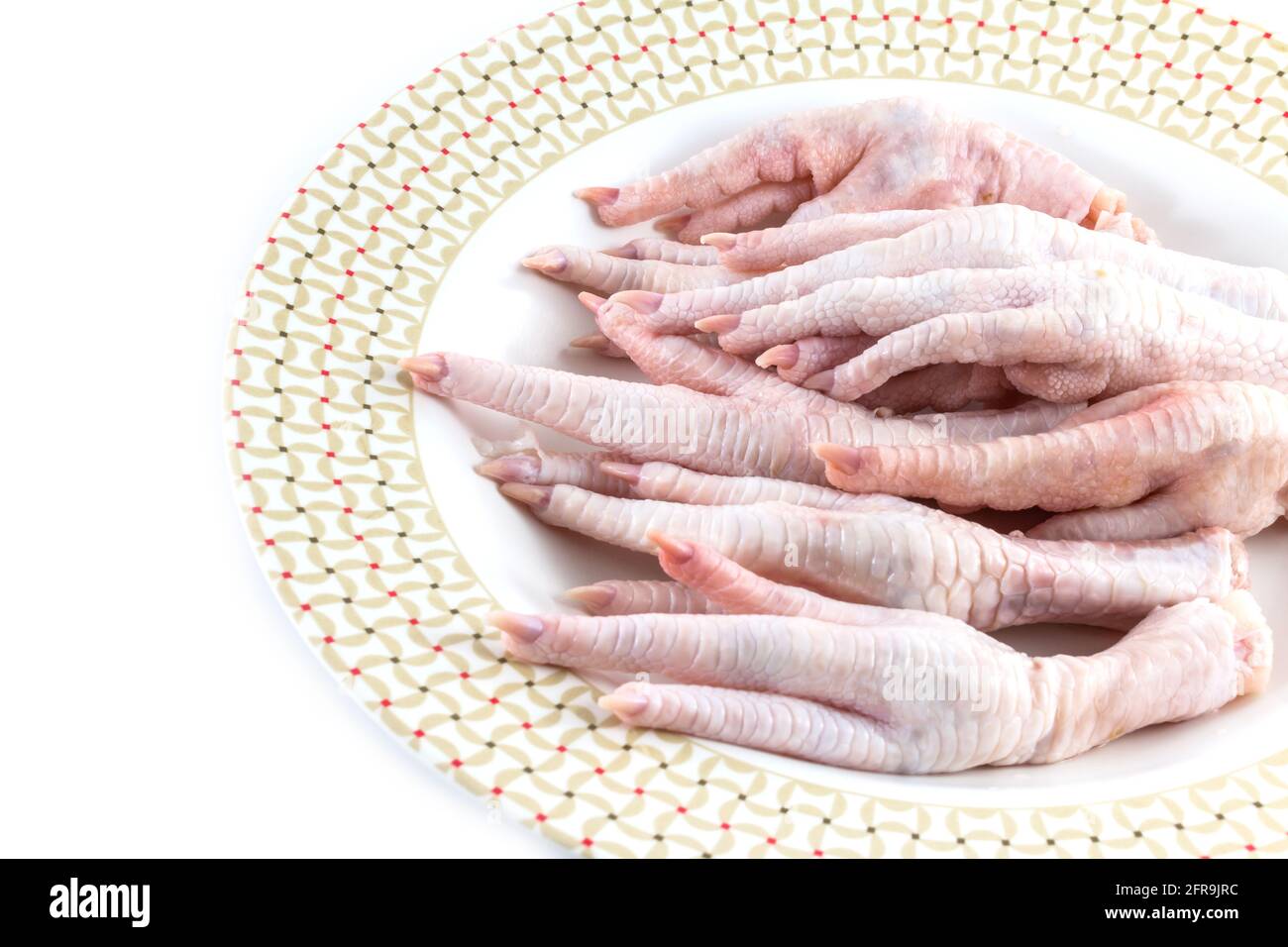Chicken feet on white disk on white background Stock Photo - Alamy