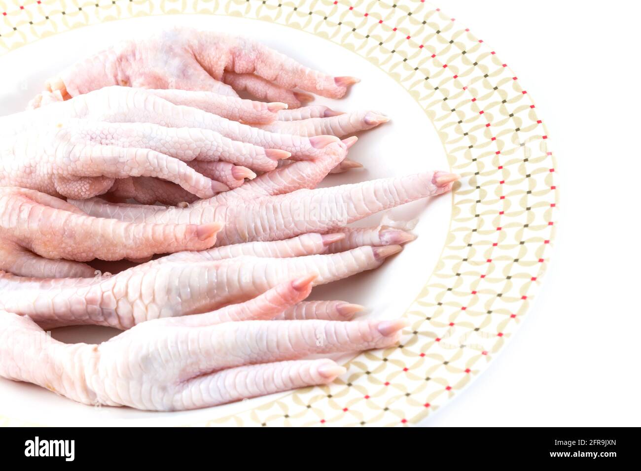 Chicken feet on white disk on white background Stock Photo - Alamy
