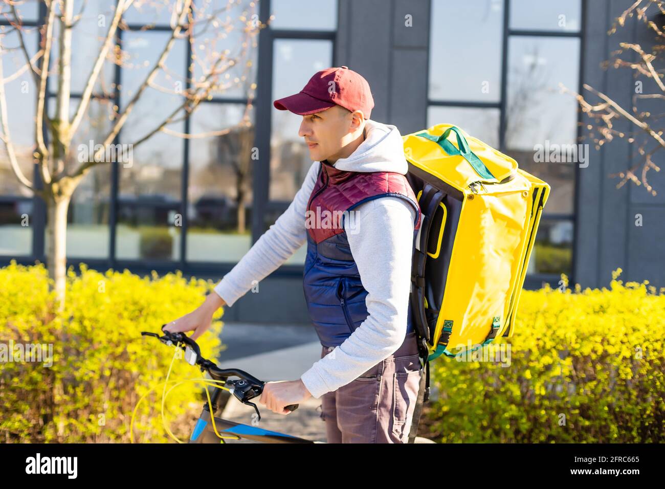 Delivery Man standing with yellow thermo backpack for food delivery ...