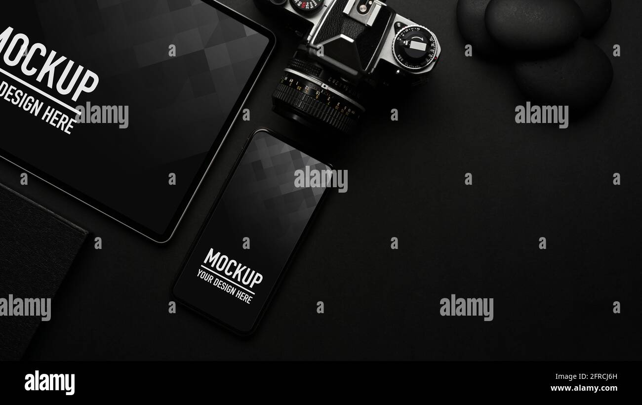 Top view of black table with smartphone, tablet, camera and copy space ...