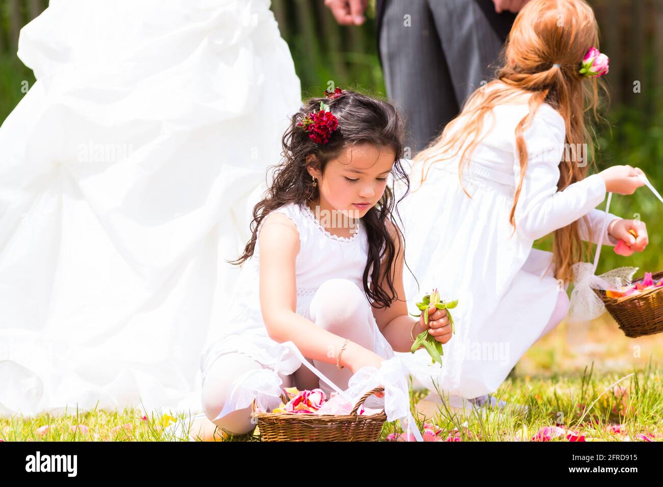 Wedding couple bride and groom with flower children or bridesmaid in ...