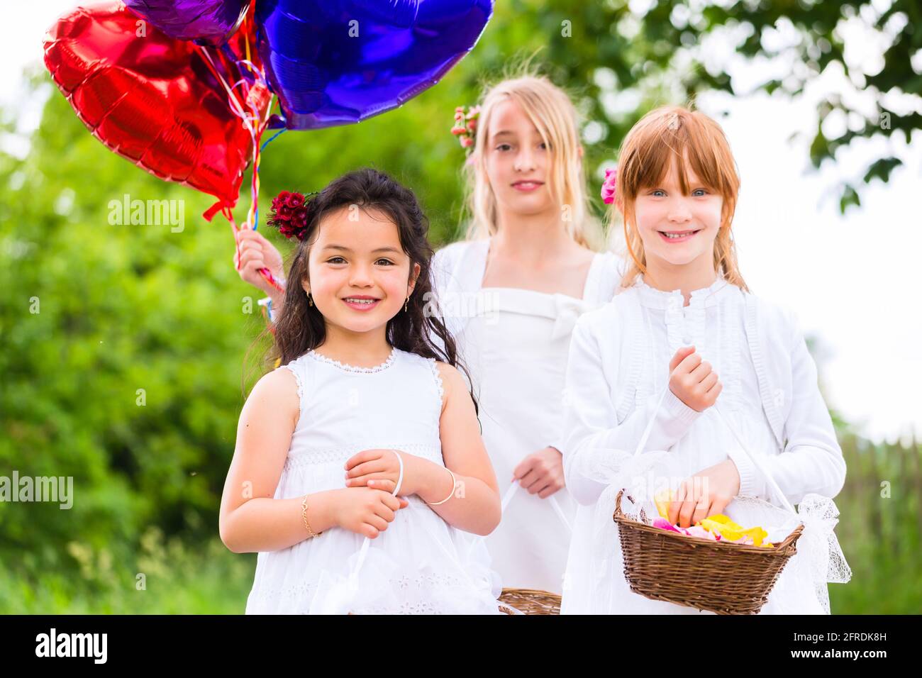 Wedding couple bride and groom with flower children or bridesmaid in ...