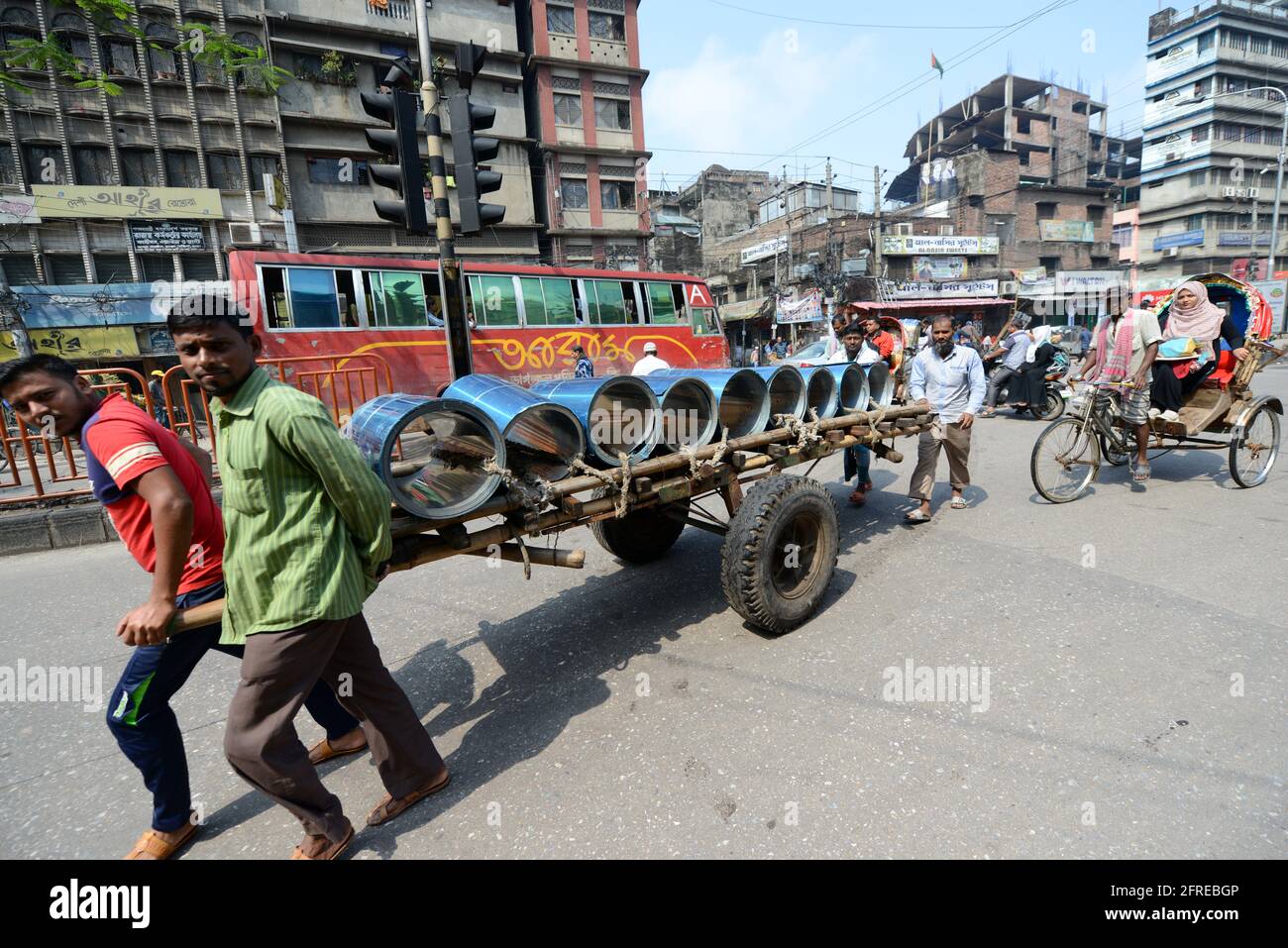 Bangladeshi men pulling a cart loaded with heavy pipes Stock Photo - Alamy