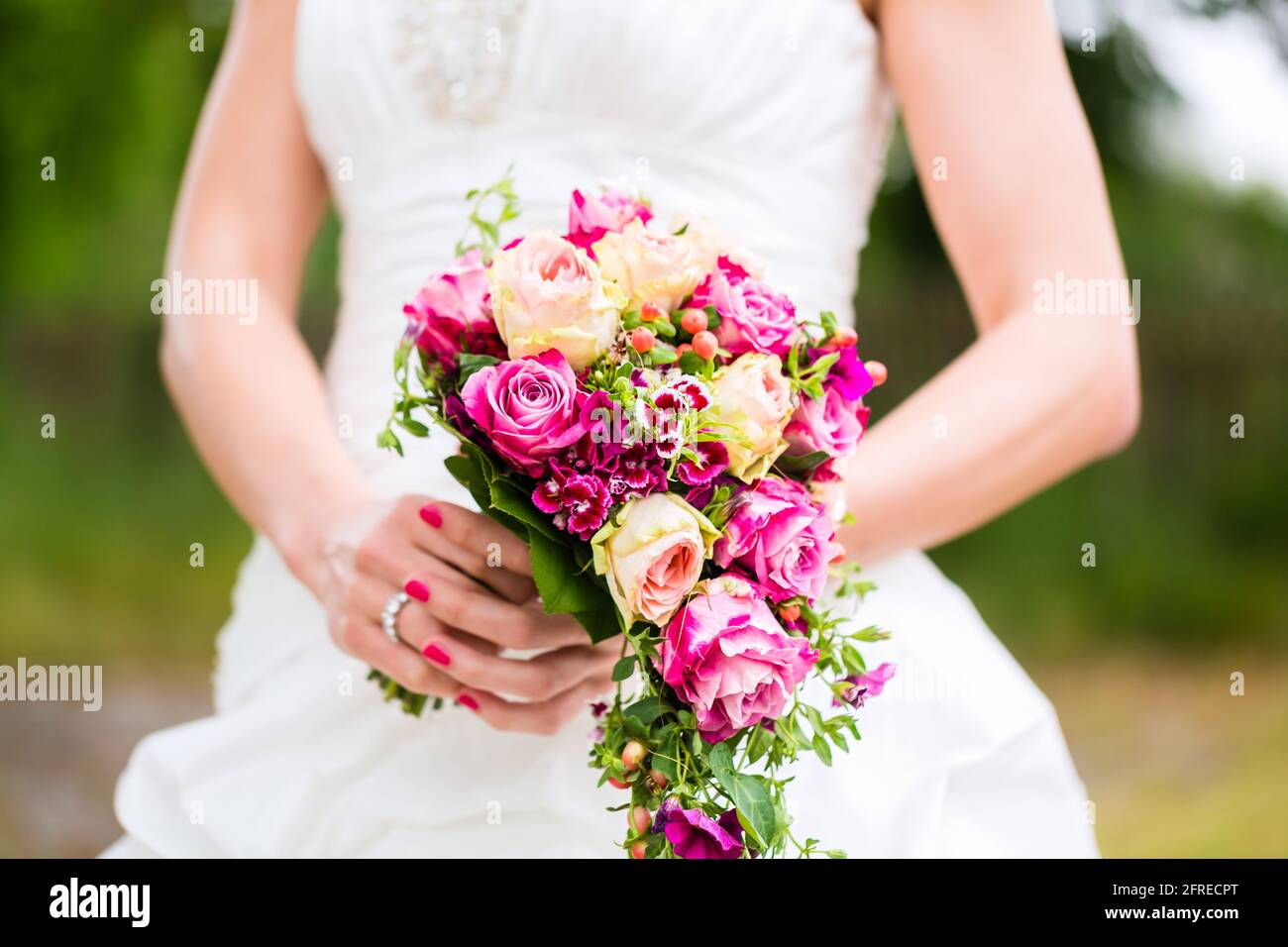 Wedding bride with bridal bouquet outside at garden Stock Photo - Alamy