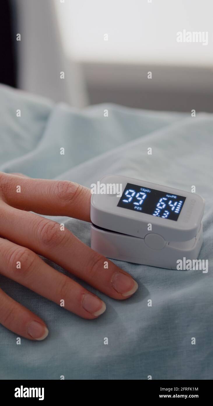 Close up of hospitalized woman with finger heart rate monitor showing ...