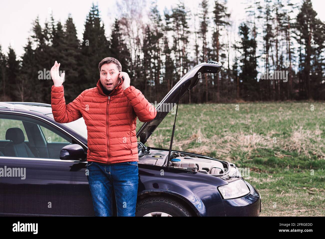 Man calling repair service after car breakdown.youg man talking on cell ...