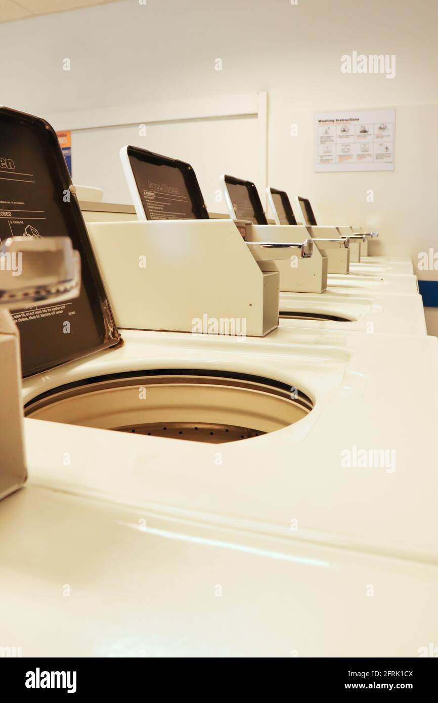 Coin slots in a row of washing machines in a laundromat Stock Photo - Alamy
