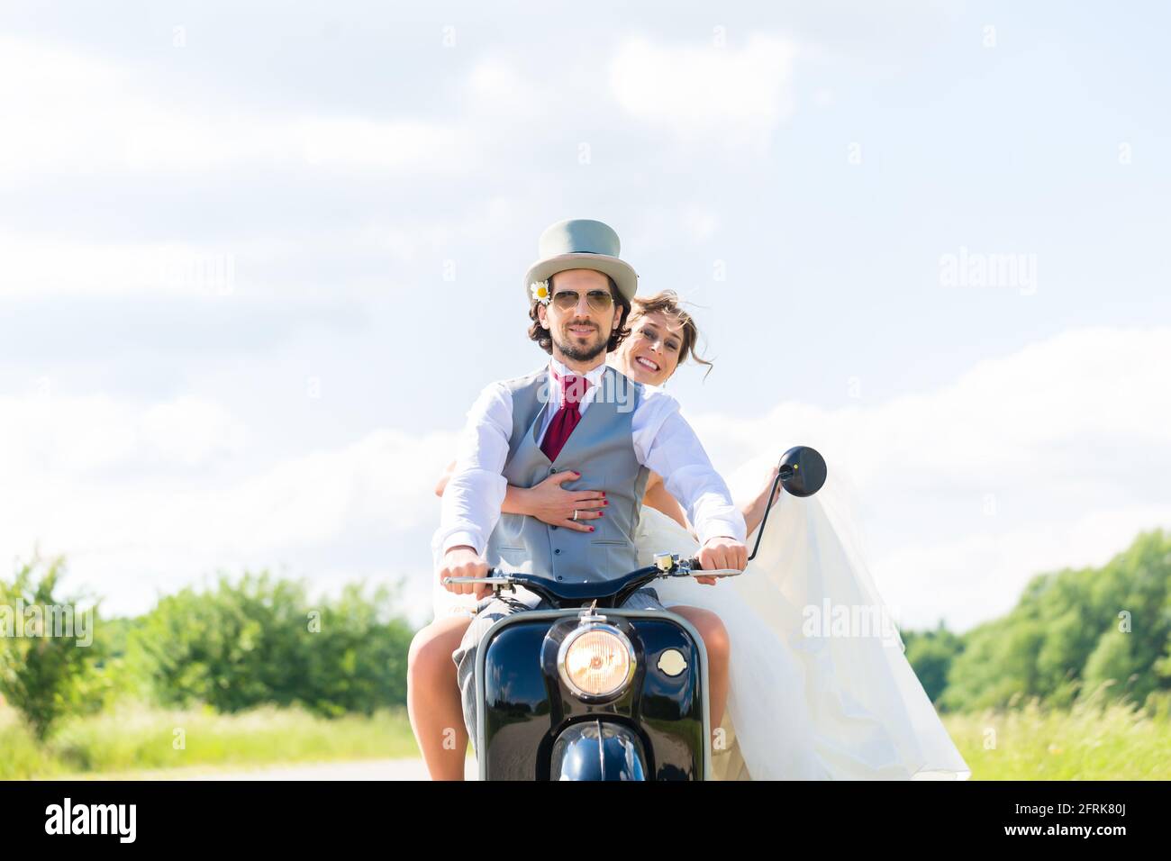 Wedding groom and bride driving motor scooter having fun Stock Photo ...