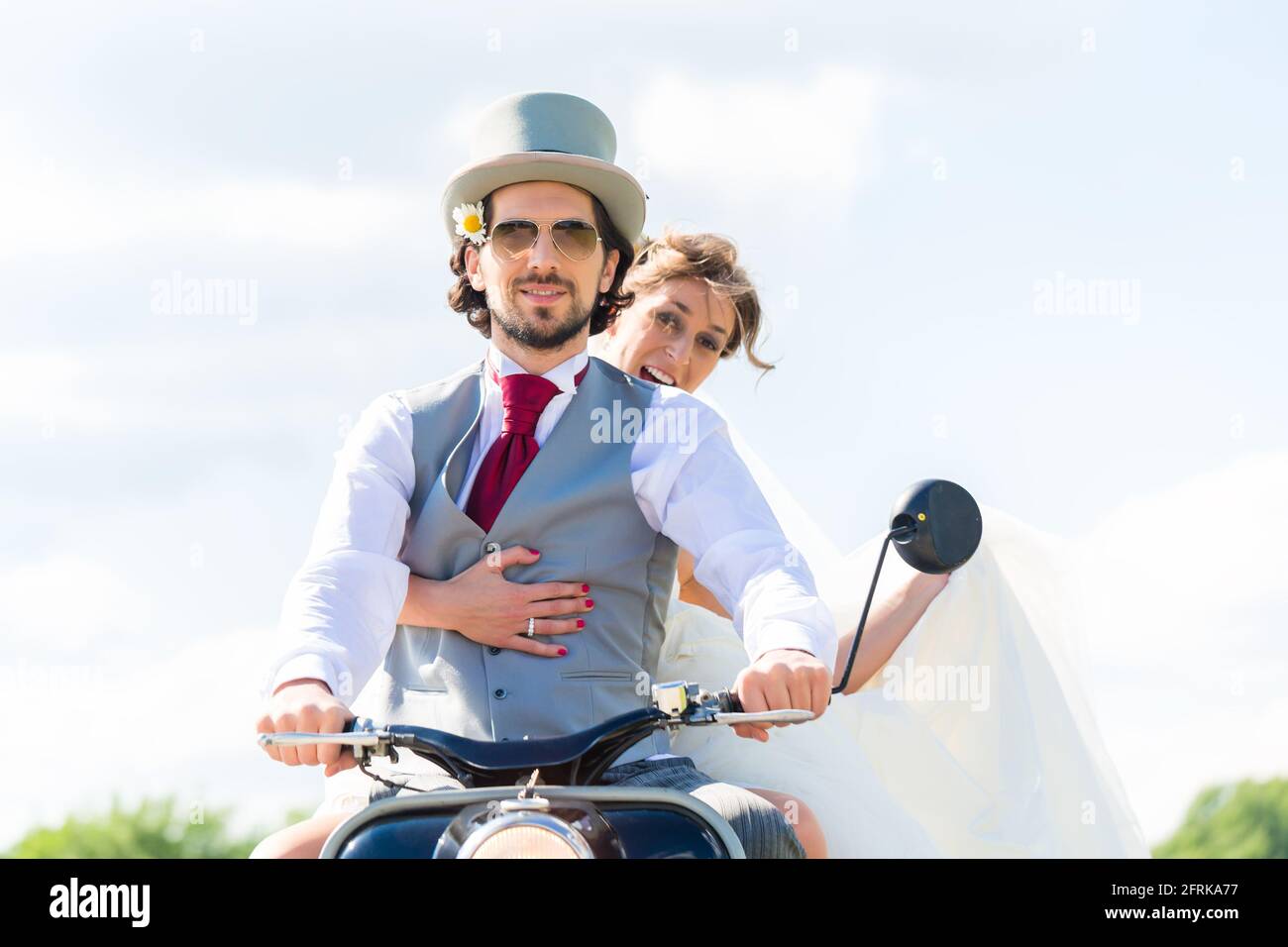 Wedding groom and bride driving motor scooter having fun Stock Photo ...