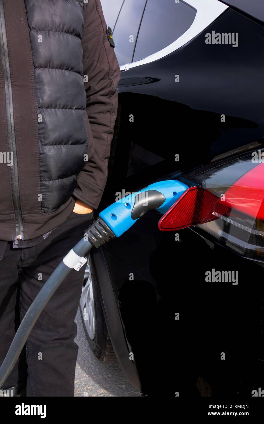 Man waiting while charging his EV car. High quality photo. Fast charger ...