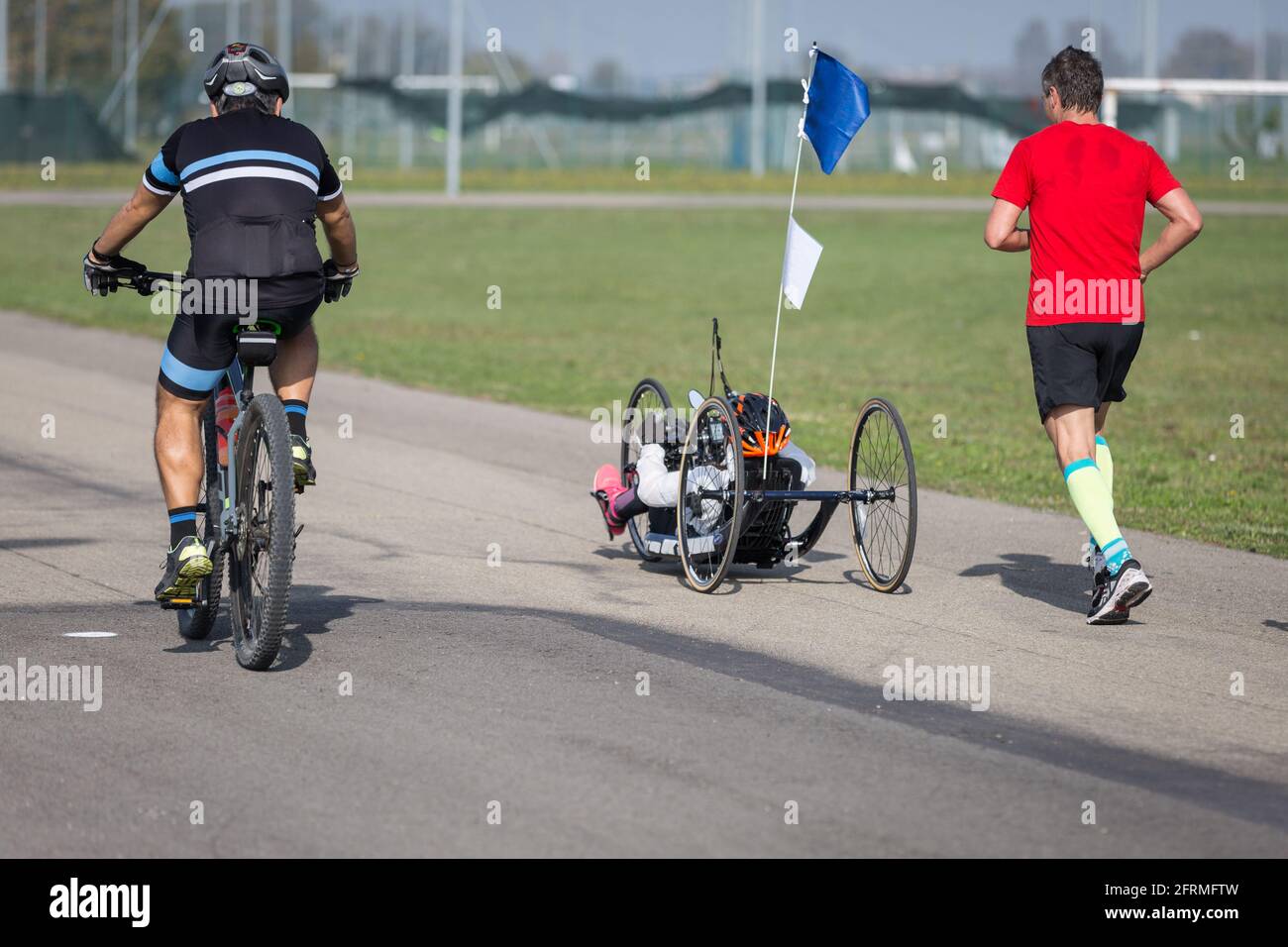 Disabled Athlete who Trains with her Hand Bike with Cyclist and Runners ...