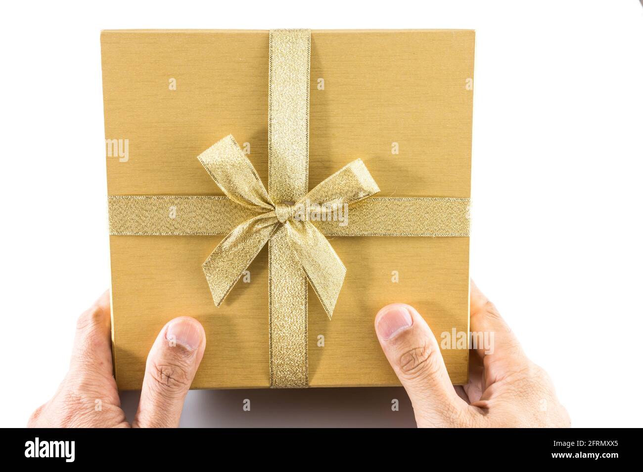 Hand give golden gift box with golden bow isolated on white background ...