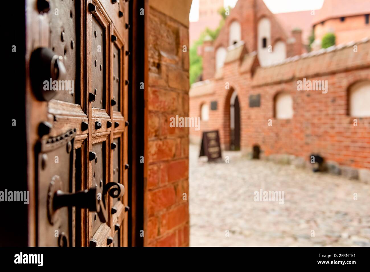 Old open wooden door with carved pattern and metal knob in a medieval ...