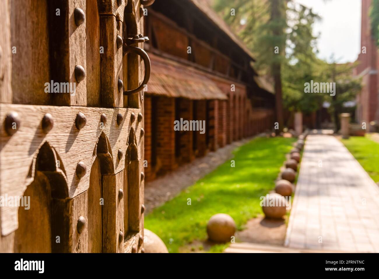 Old open wooden door with carved pattern and metal knob in a medieval ...