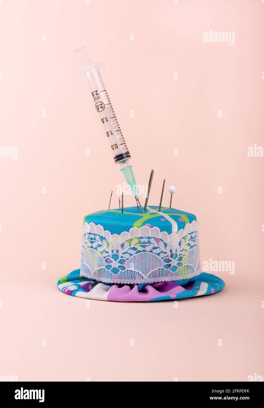 A medical syringe in a needle pad among sewing needles. Copy space ...