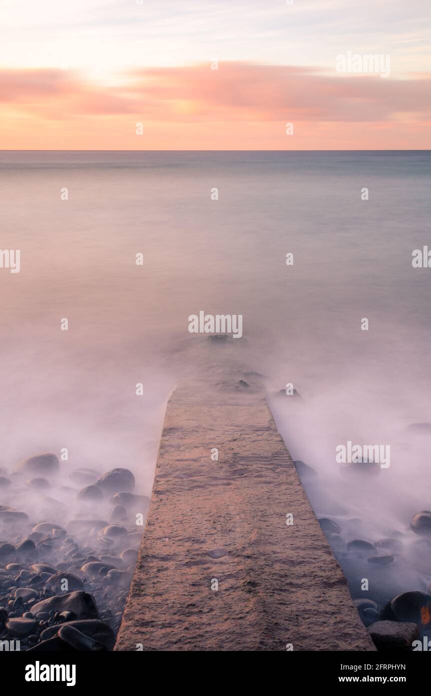 Stone jetty leading into the sea at sunrise, Madeira Stock Photo - Alamy