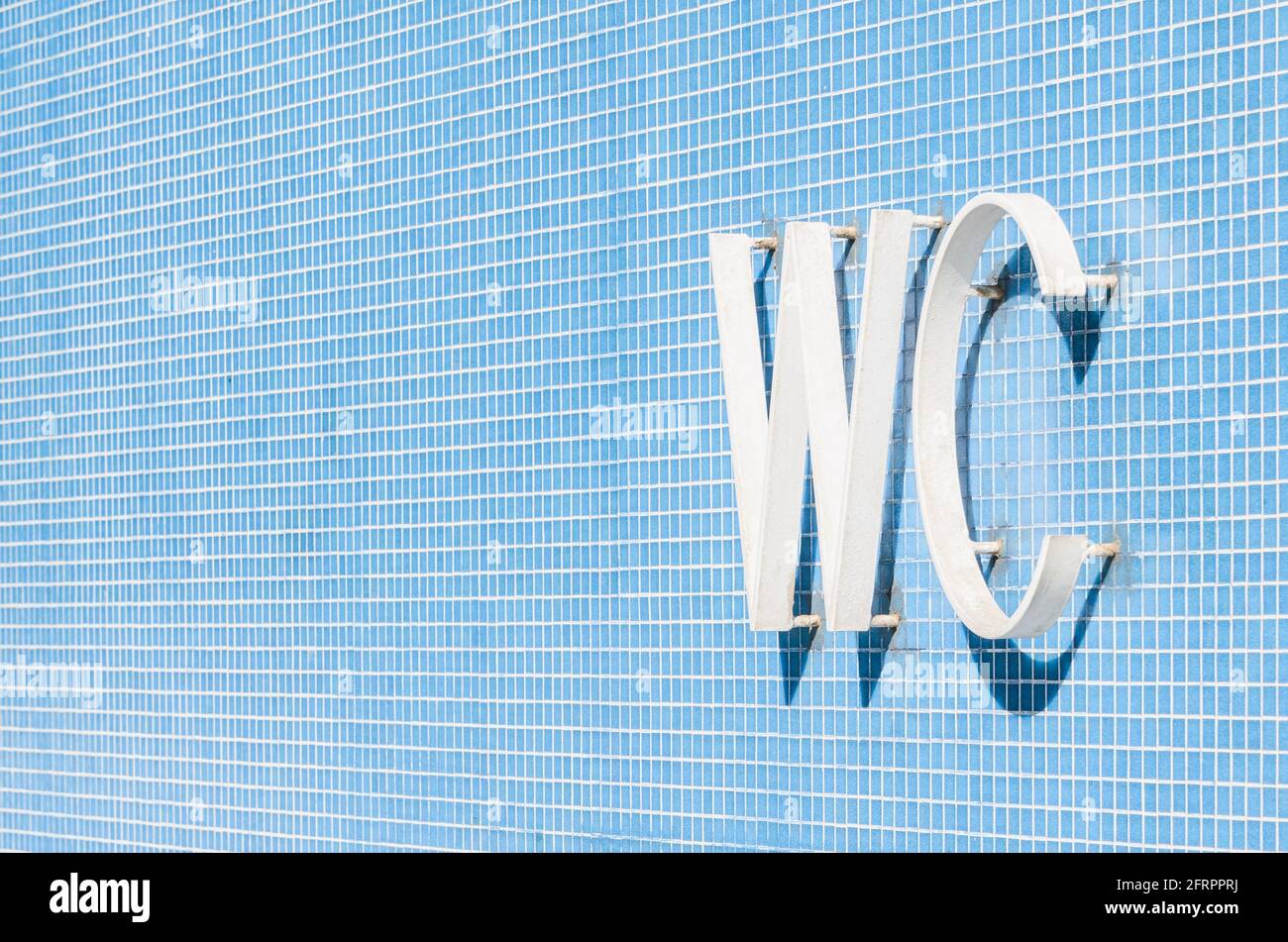 WC sign for toilet on blue wall Stock Photo - Alamy