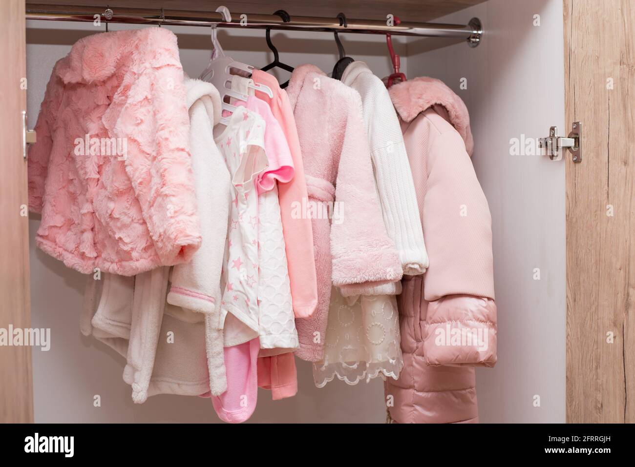 Children clothes hanging on hangers in the wardrobe Stock Photo - Alamy