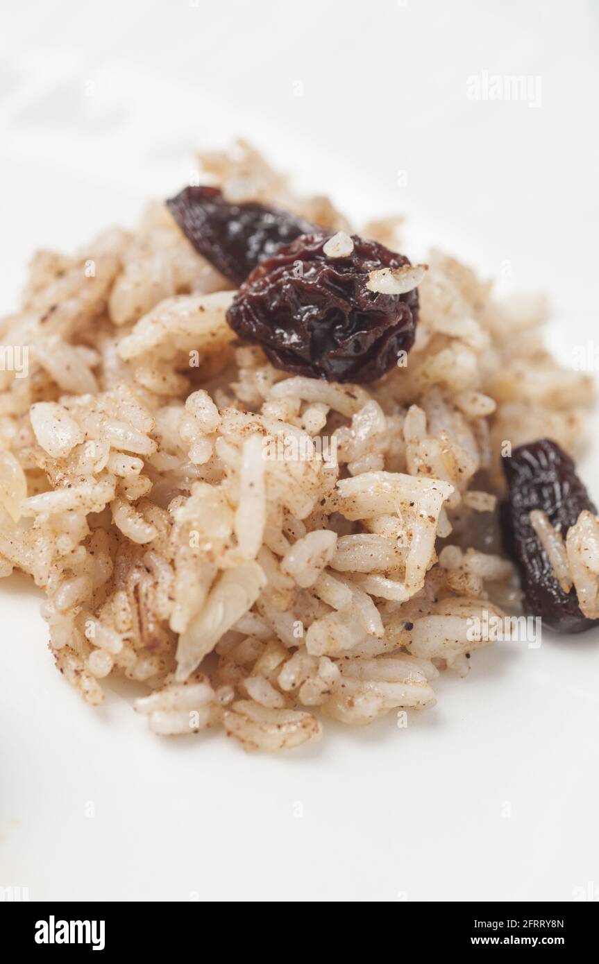 Vertical shot of cooked rice with raisins on a white plate Stock Photo ...