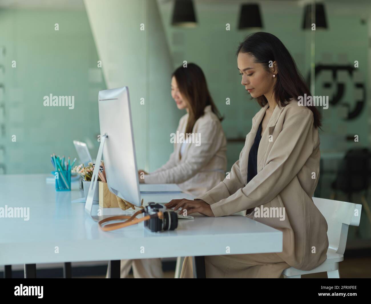 Side view of two female office workers working on their work in office ...