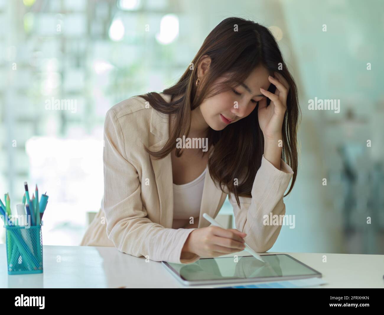 Portrait of businesswoman feeling tried while working with tablet in ...