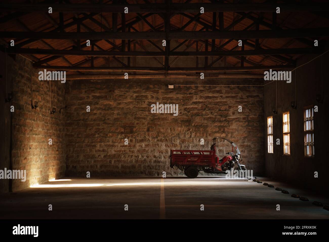 Tricycle isolated in a stone building with windows Stock Photo - Alamy