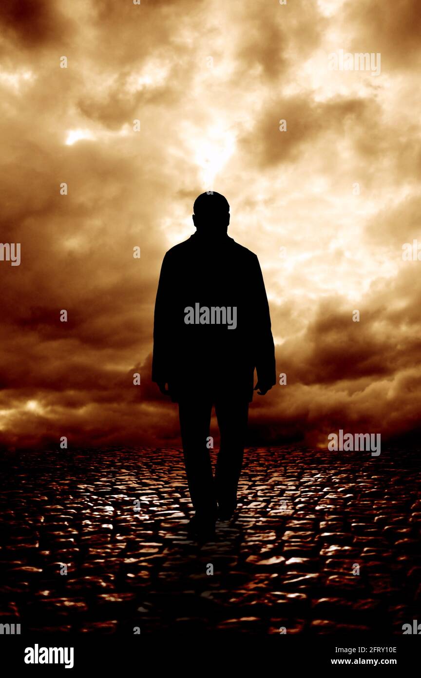 mysterious silhouette of a man walking away in a dark land Stock Photo - Alamy