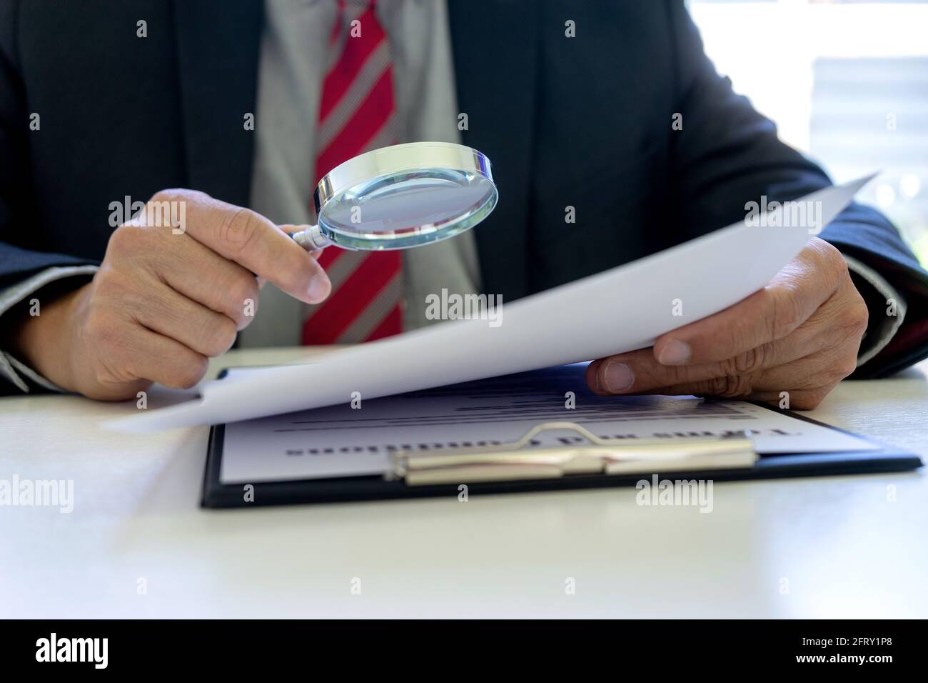 Lawyer or judge use magnifier glass look to the paper for inspection ...