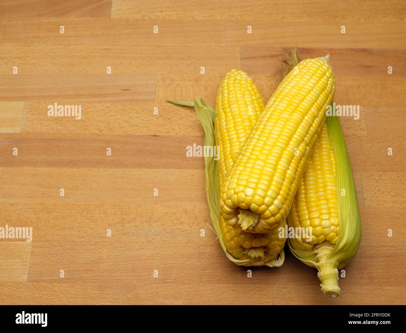 Top view of corns and corn on the cop isolated on wooden table with ...