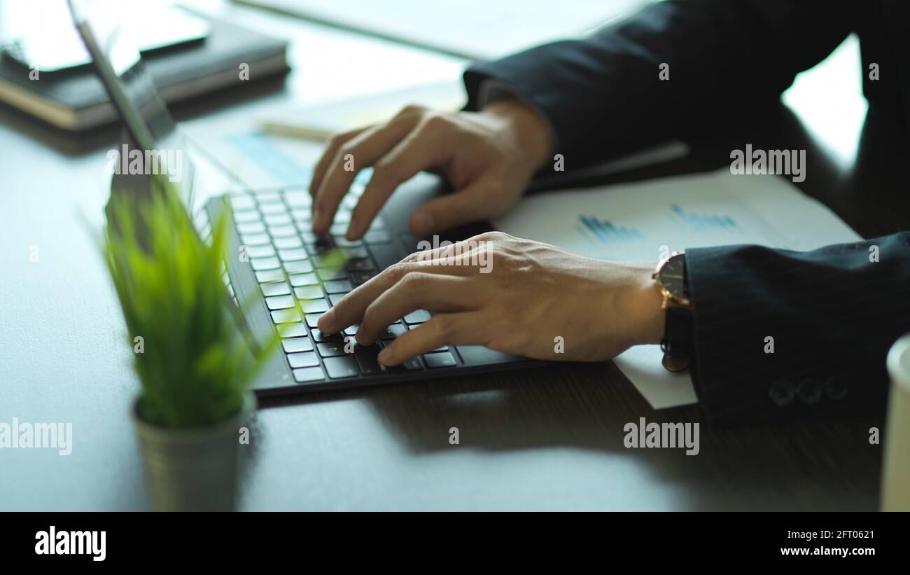 Side view of businessman hands typing on tablet keyboard on office desk ...