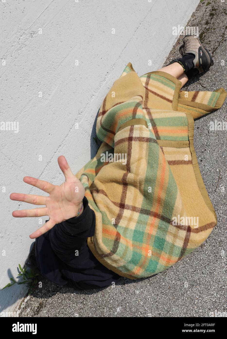 poor man under a blanket who raises his hand to say Enough of the ...