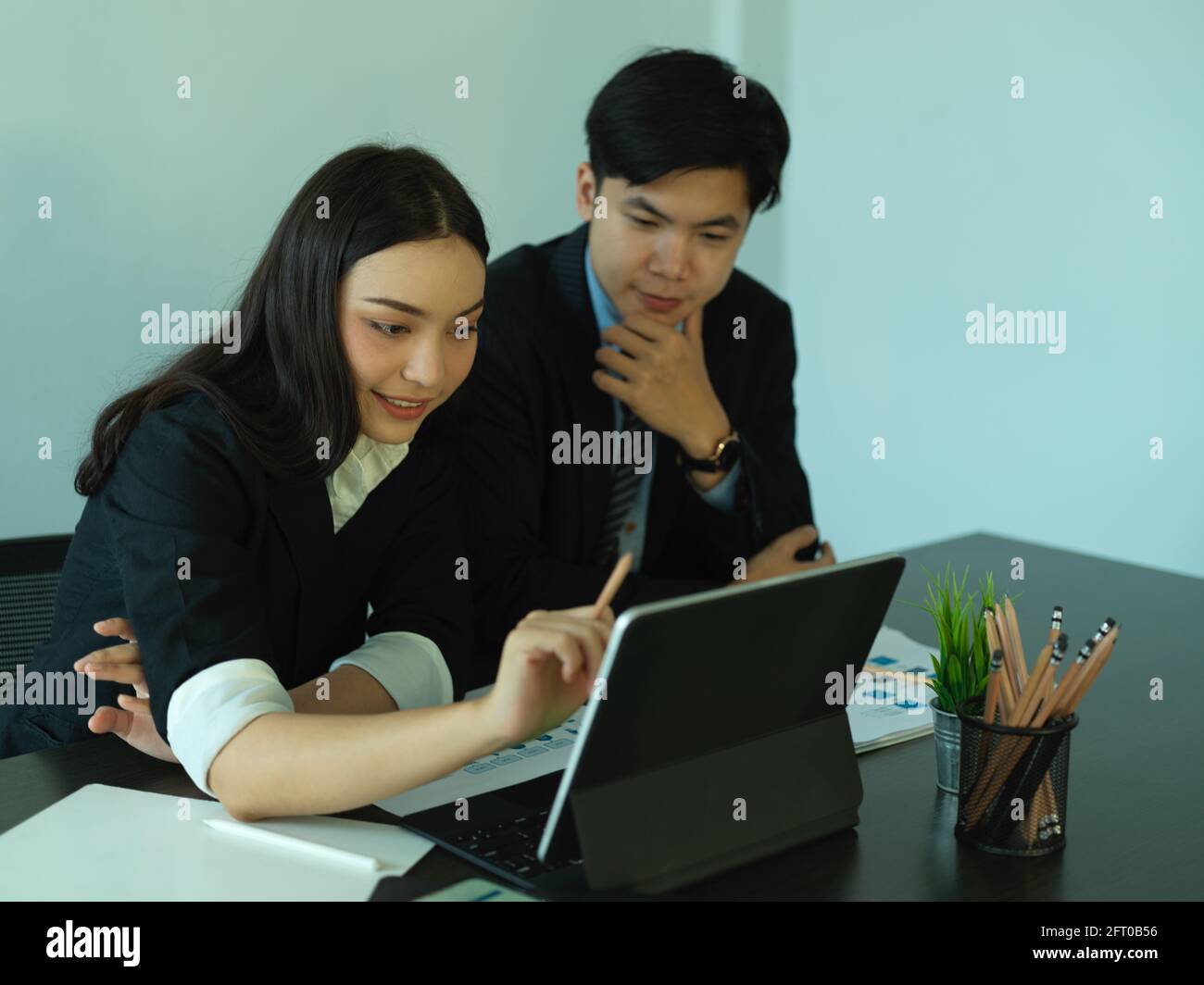 Side view of business team consulting on their project with tablet and ...