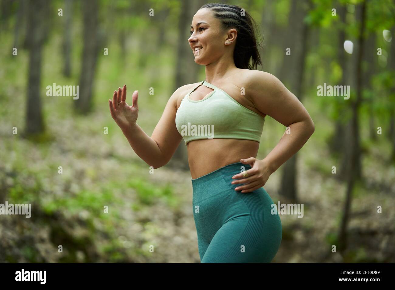 Beautiful plus size runner woman running on a dirt road in the forest ...