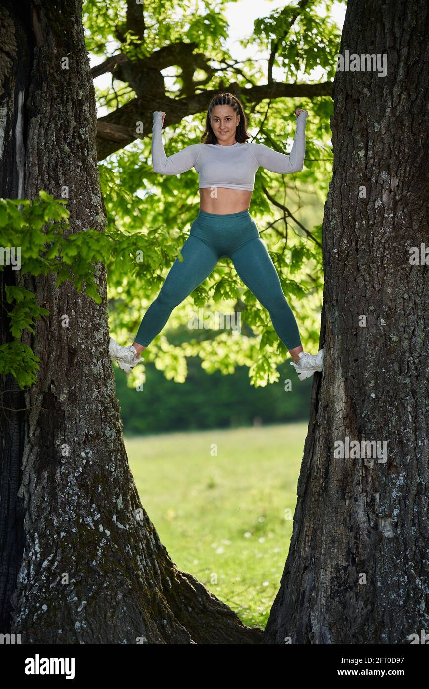 Size plus young woman climbing in an oak tree Stock Photo - Alamy