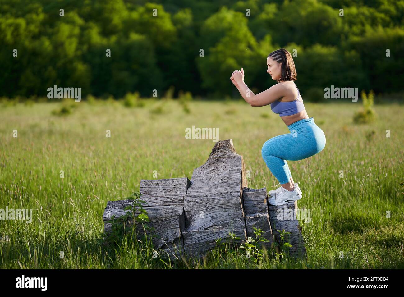 Size plus young woman in sport attire doing fitness exercises with body ...
