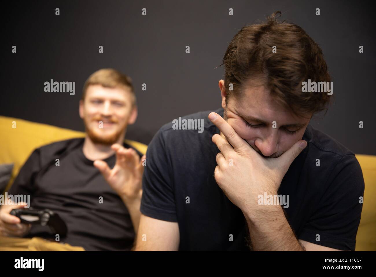 gamer covered his face with palm. Smiling opponent comforts video game ...
