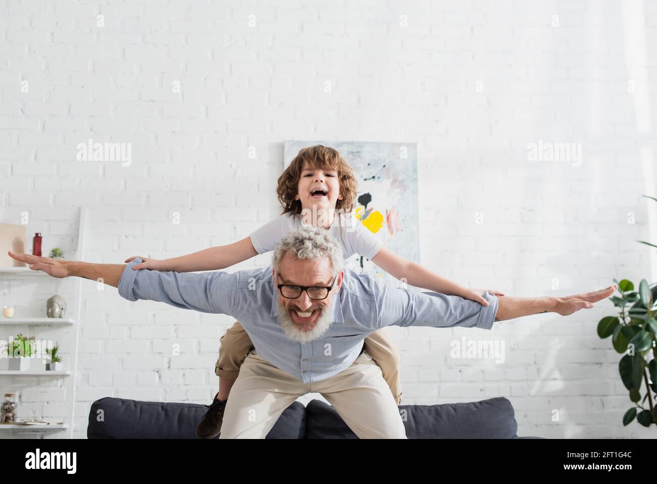 Happy mature man playing with kid at home Stock Photo - Alamy