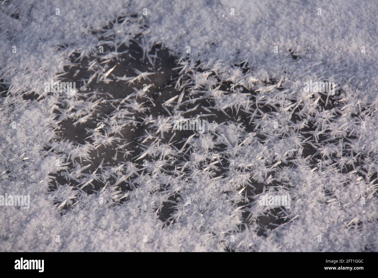white ice crystals on a dark surface of solid ice Stock Photo - Alamy