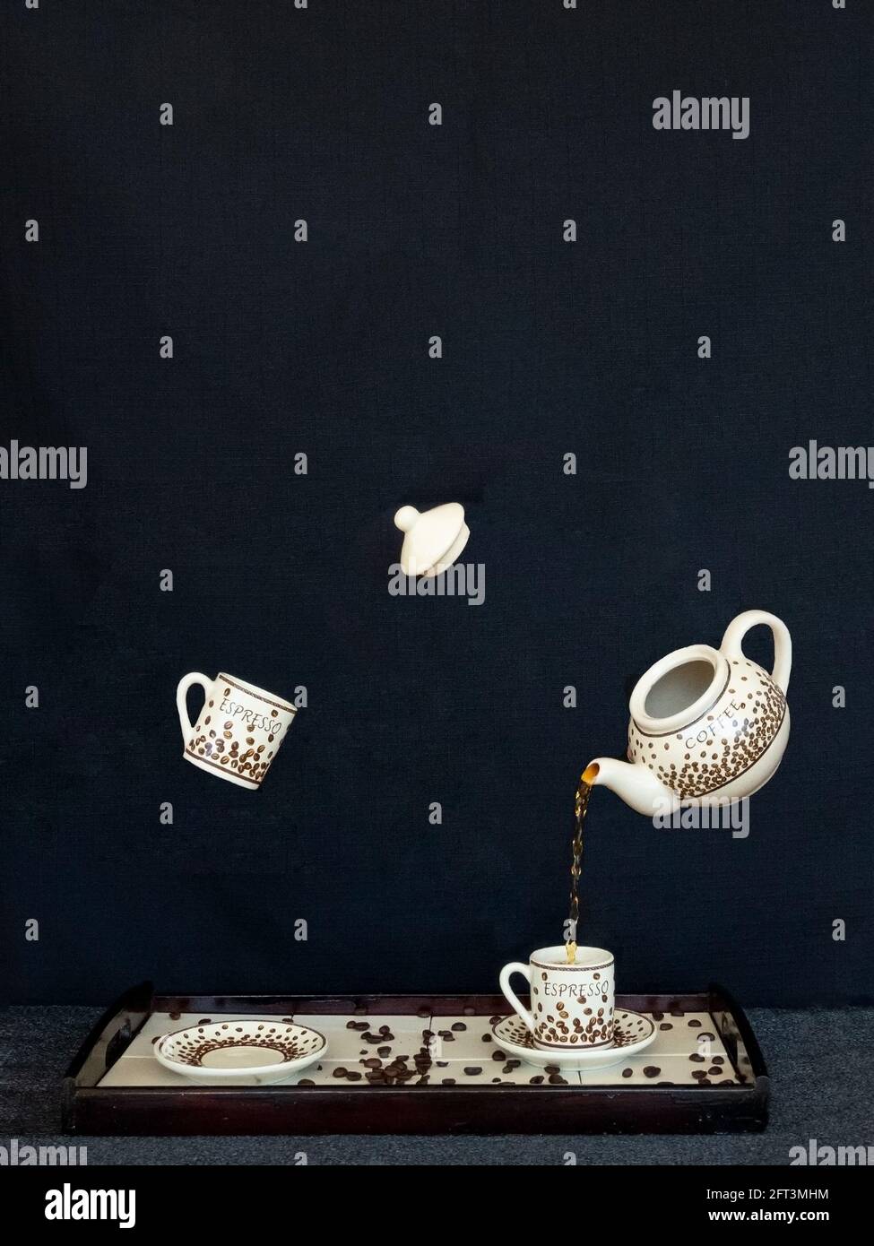 Vertical shot of coffee being magically poured into a cup with another ...