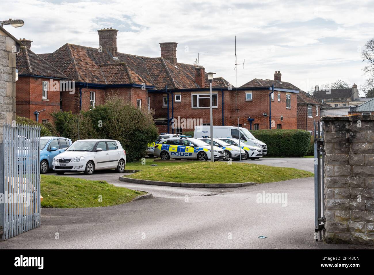 A variety of police cars and a police van parked up outside the back of ...