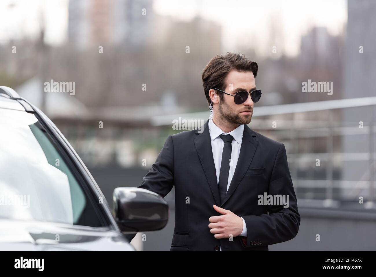 bearded bodyguard in suit and sunglasses with security earpiece ...