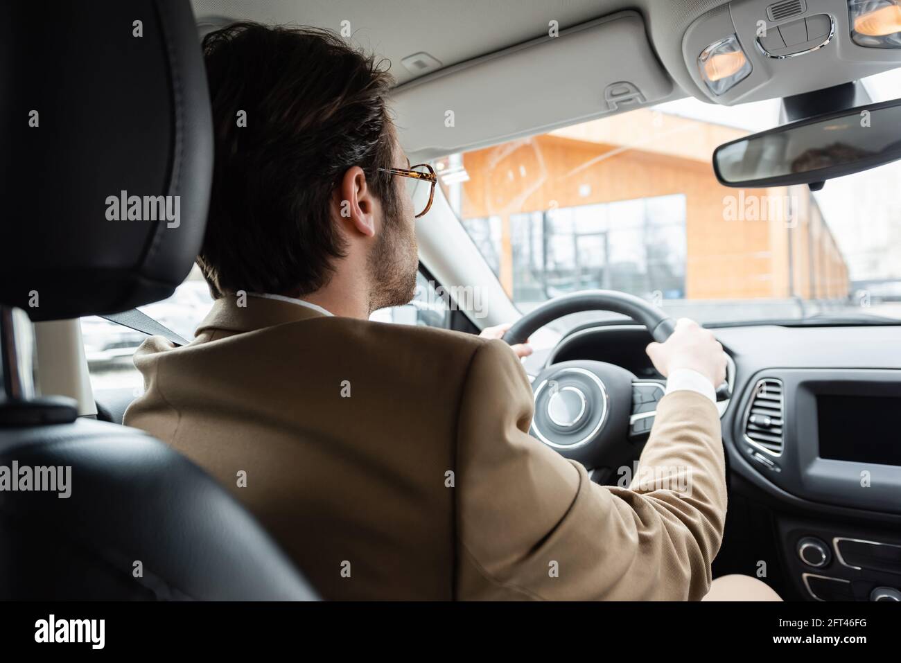 back view of man in jacket driving car Stock Photo - Alamy