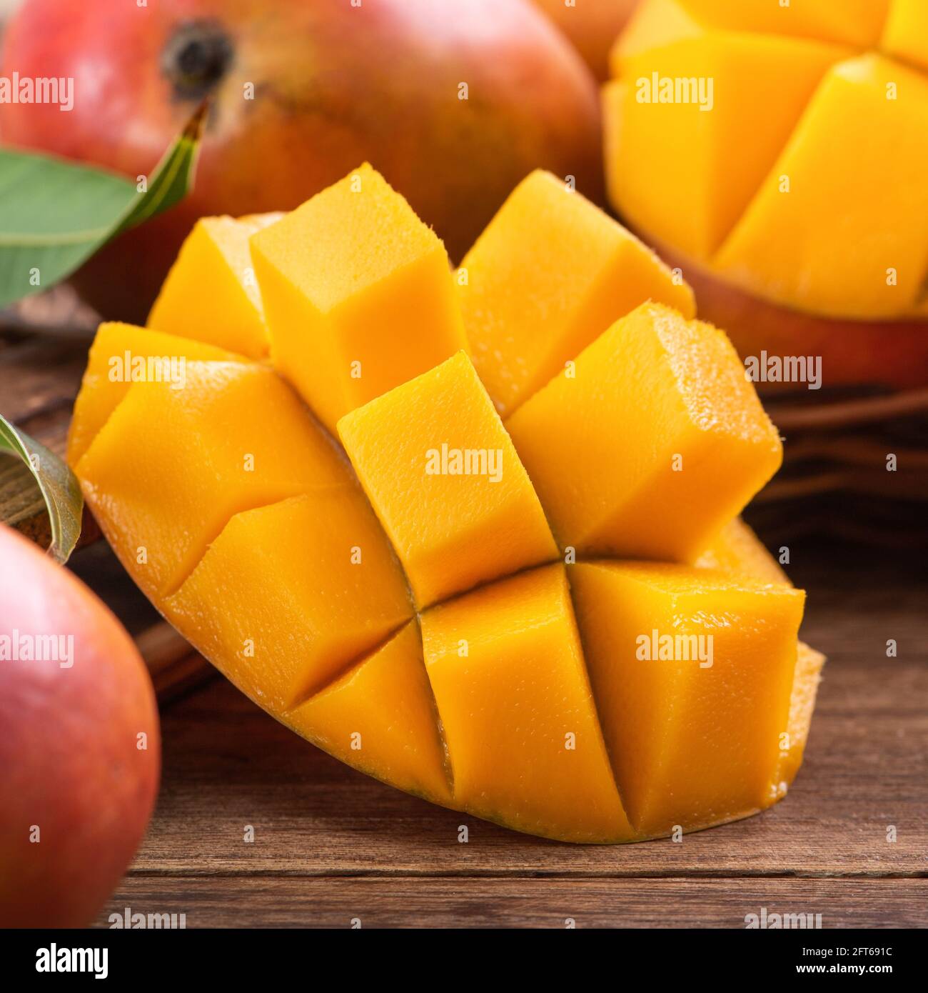 Mango. Close up of fresh ripe mango fruit with leaves over dark wooden ...
