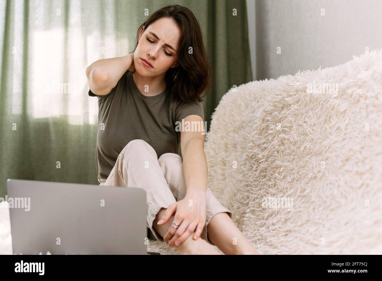 A business woman suffering from pain in neck, stretching up. Tired ...