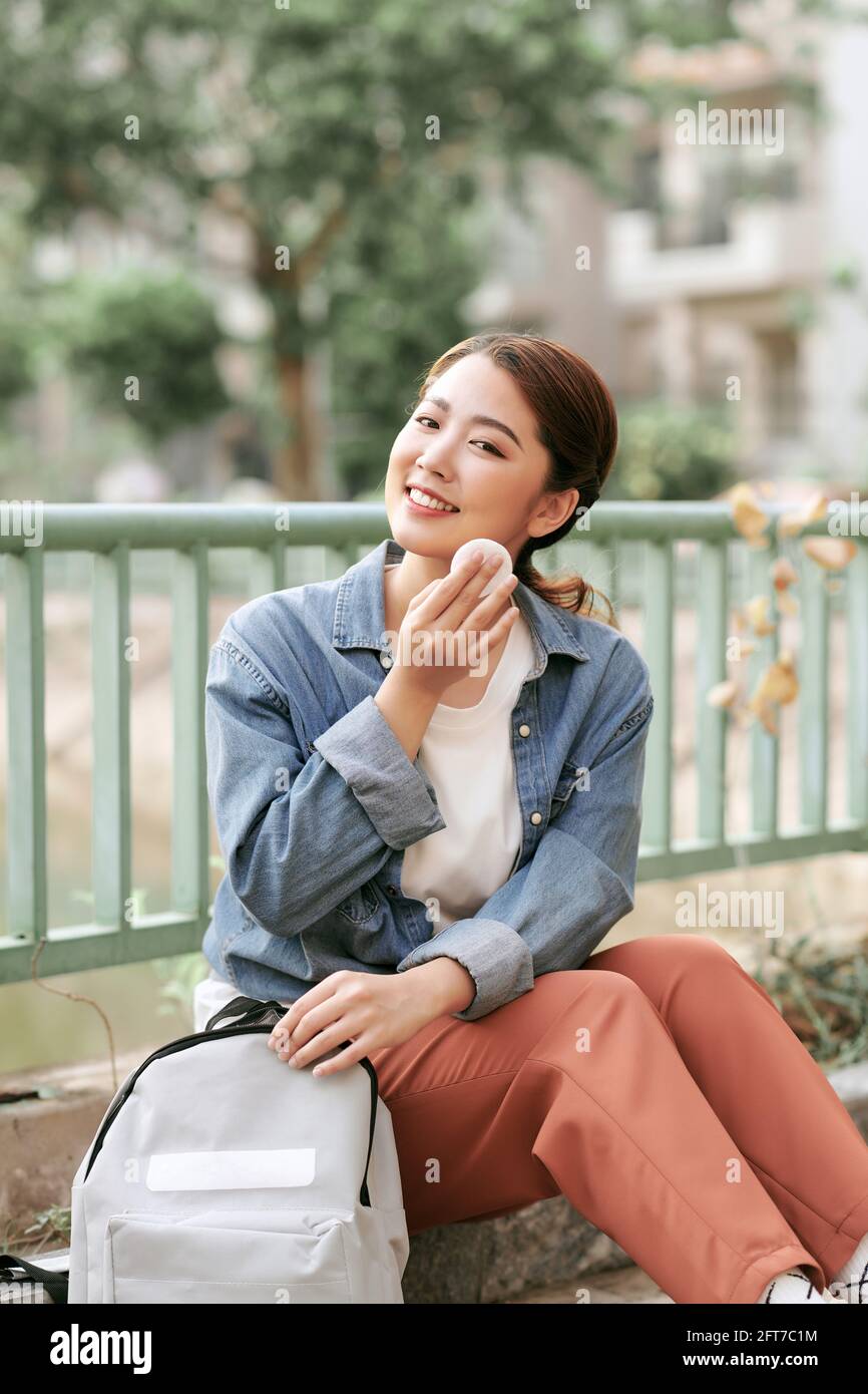 Attractive beautiful girl uses facial tissue for sweating on her face ...