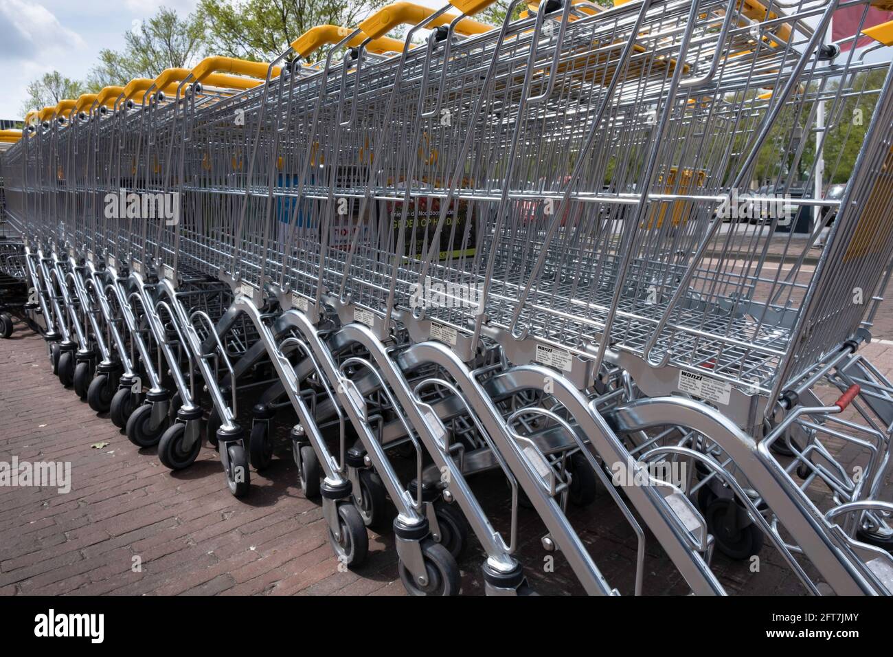 Row of shiny metal yellow plastic shopping carts in an open-air ...
